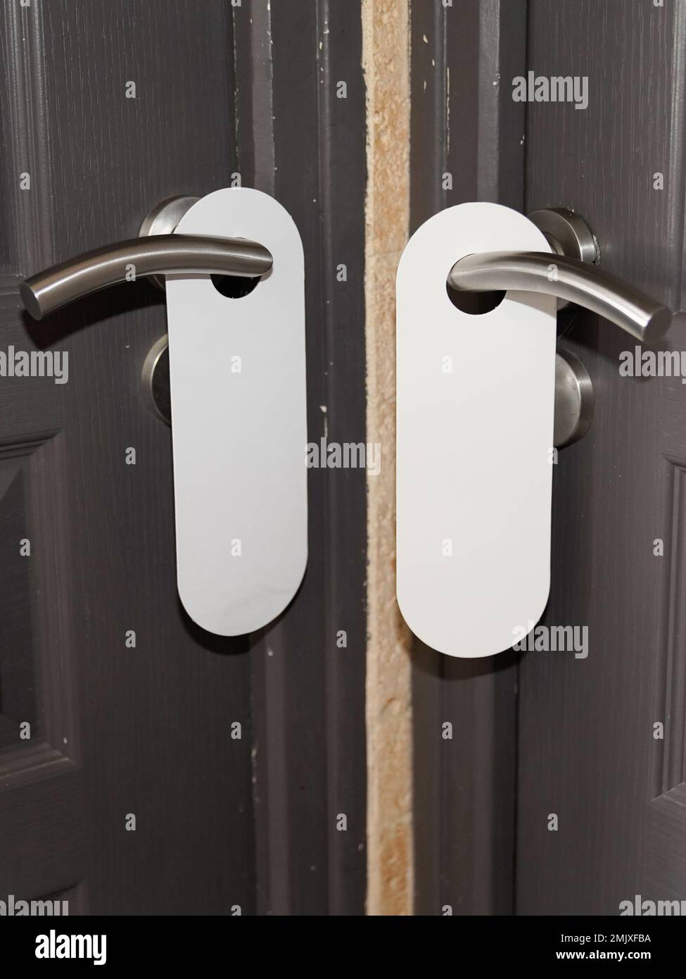 Sign on two white door hanger handle with empty plate do not disturb ...