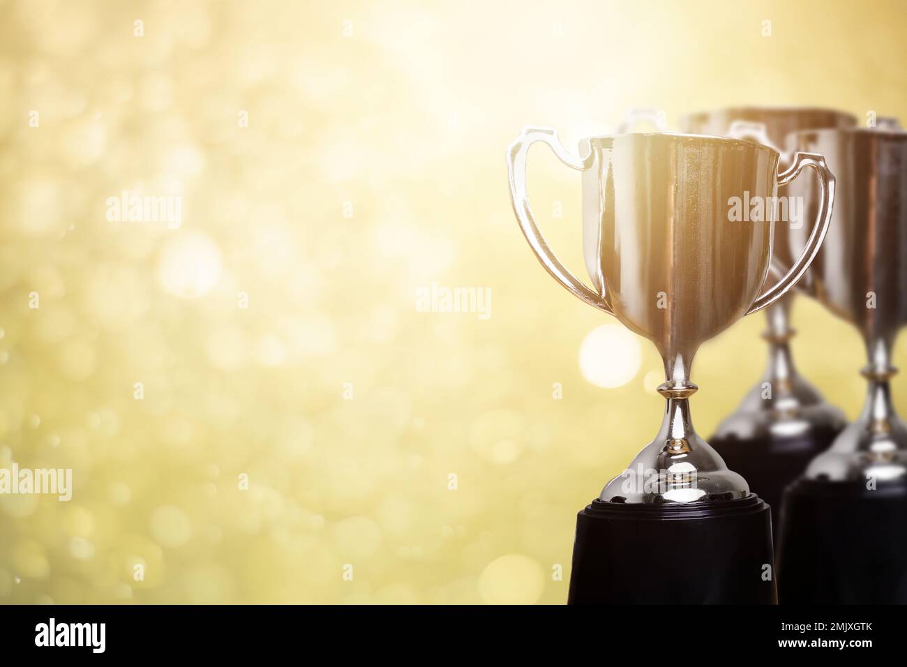 golden trophy award with bokeh soft gold background. copy space for ...