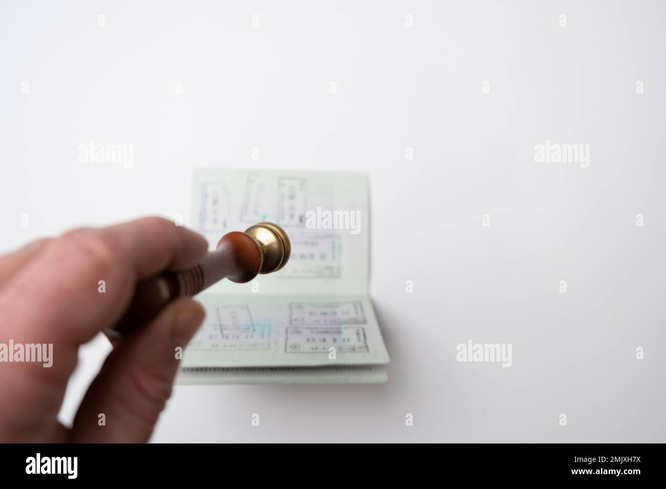 a german passport on a white background and a stamp standing next to it ...