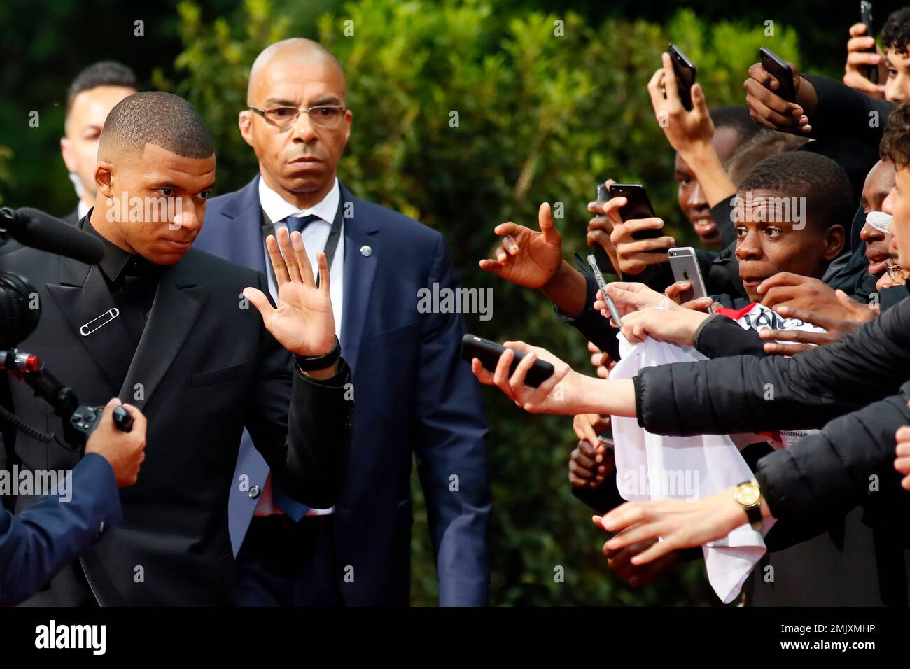 Paris Saint Germain's Kylian Mbappe waves to fans as he arrives at the ...