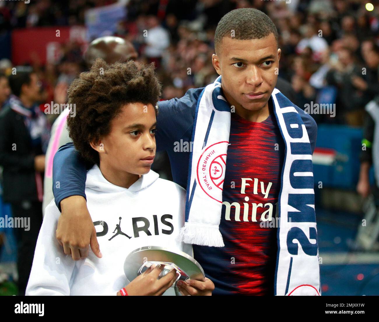 PSG's Kylian Mbappe with a kid, no name available, walks after the ...