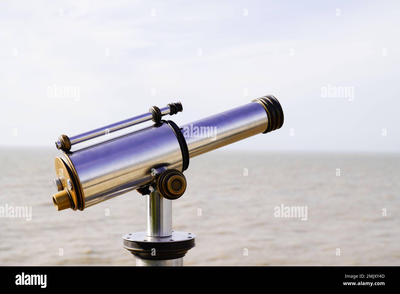 Touristic old seaside pay to view silver telescope stands Stock Photo ...