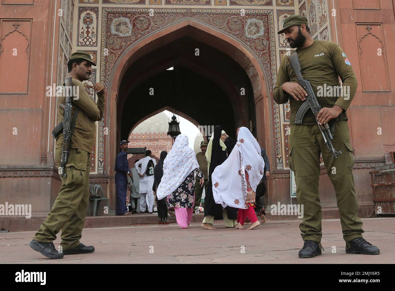 Pakistani police officers stand guard at the Badshahi mosque as people ...