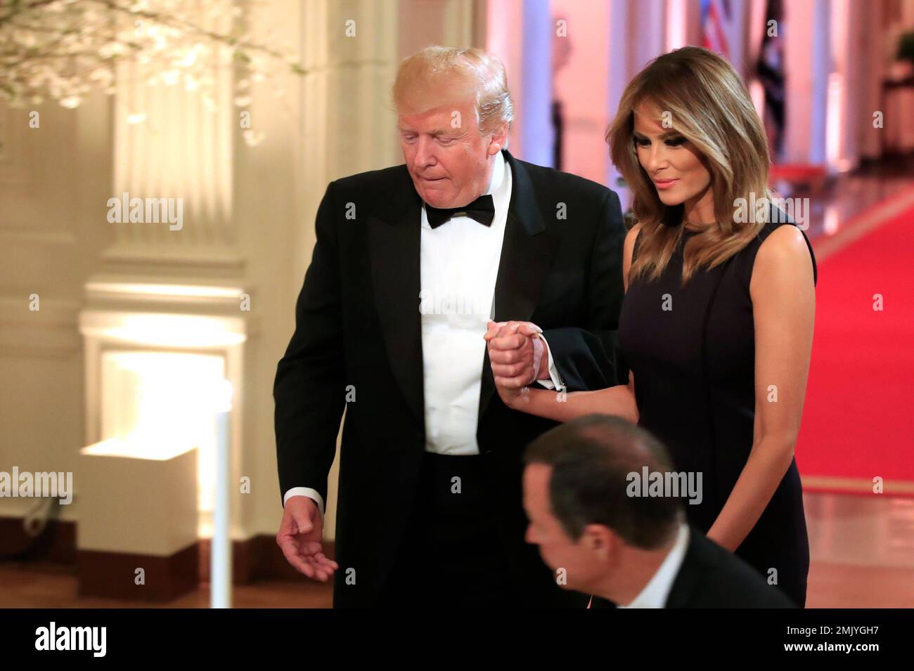 President Donald Trump walks with first lady Melania Trump to her seat ...