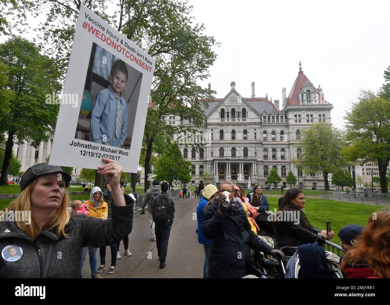 Stacy Alamond of Rome, N.Y., holds a poster of her son who died from a ...