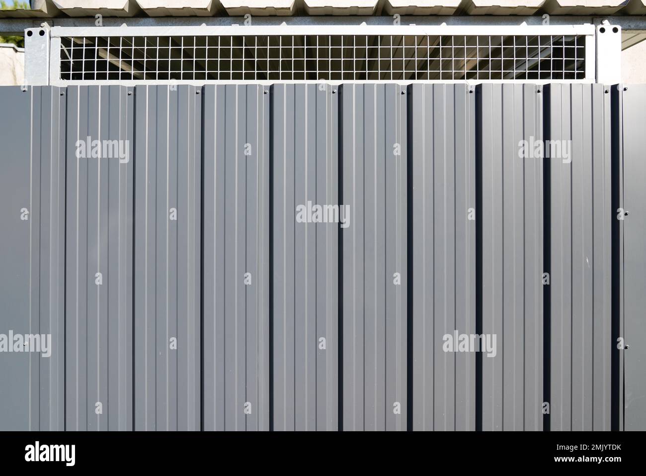 steel vertical striated metal wall with mesh on the upper part ...
