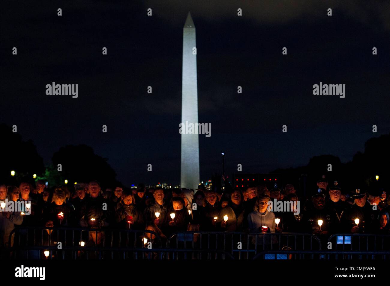 People hold candles, as the Washington Monument stands in the ...
