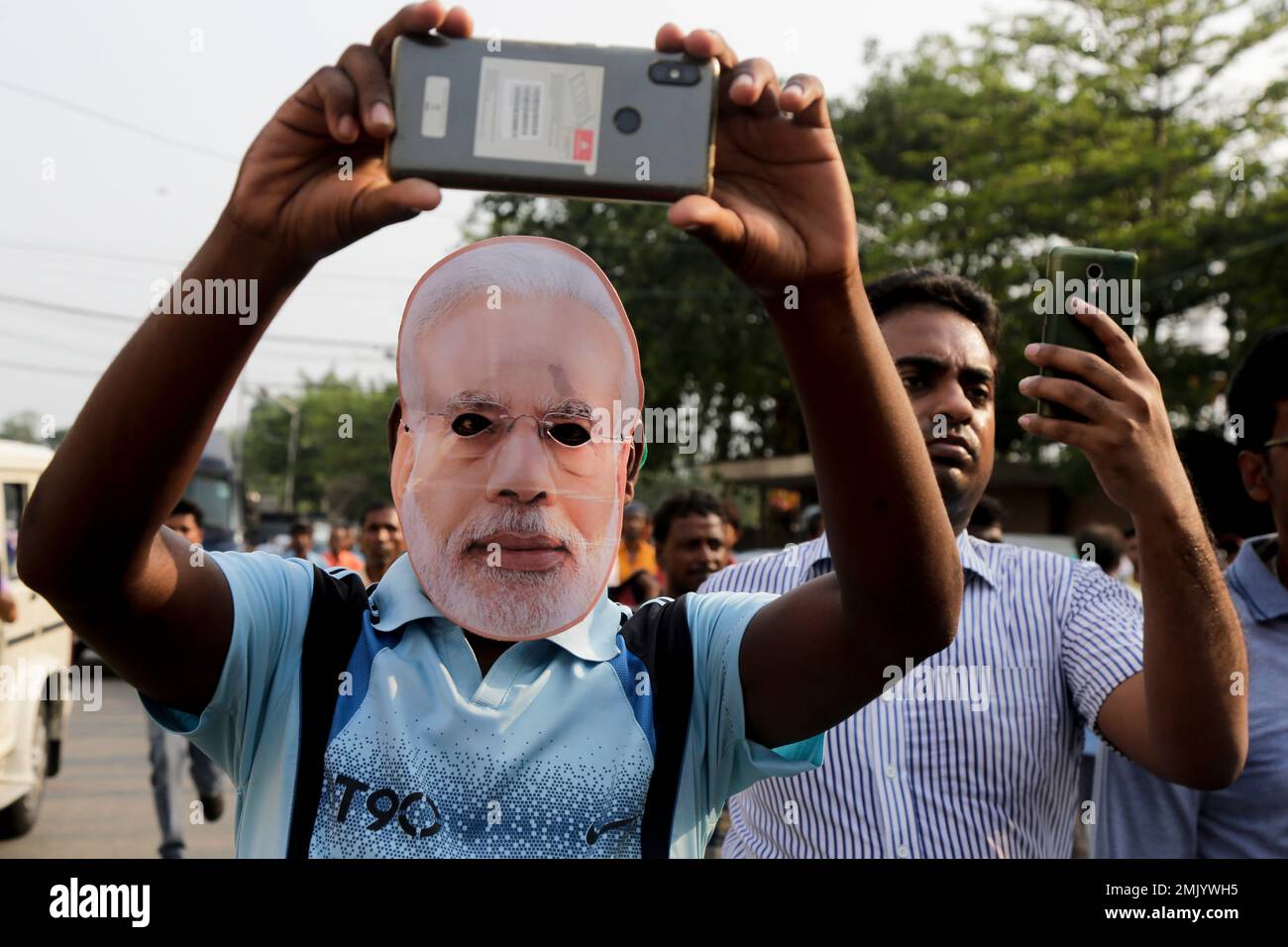 A supporter of India's ruling Bharatiya Janata party (BJP) wearing a mask of Indian Prime ...