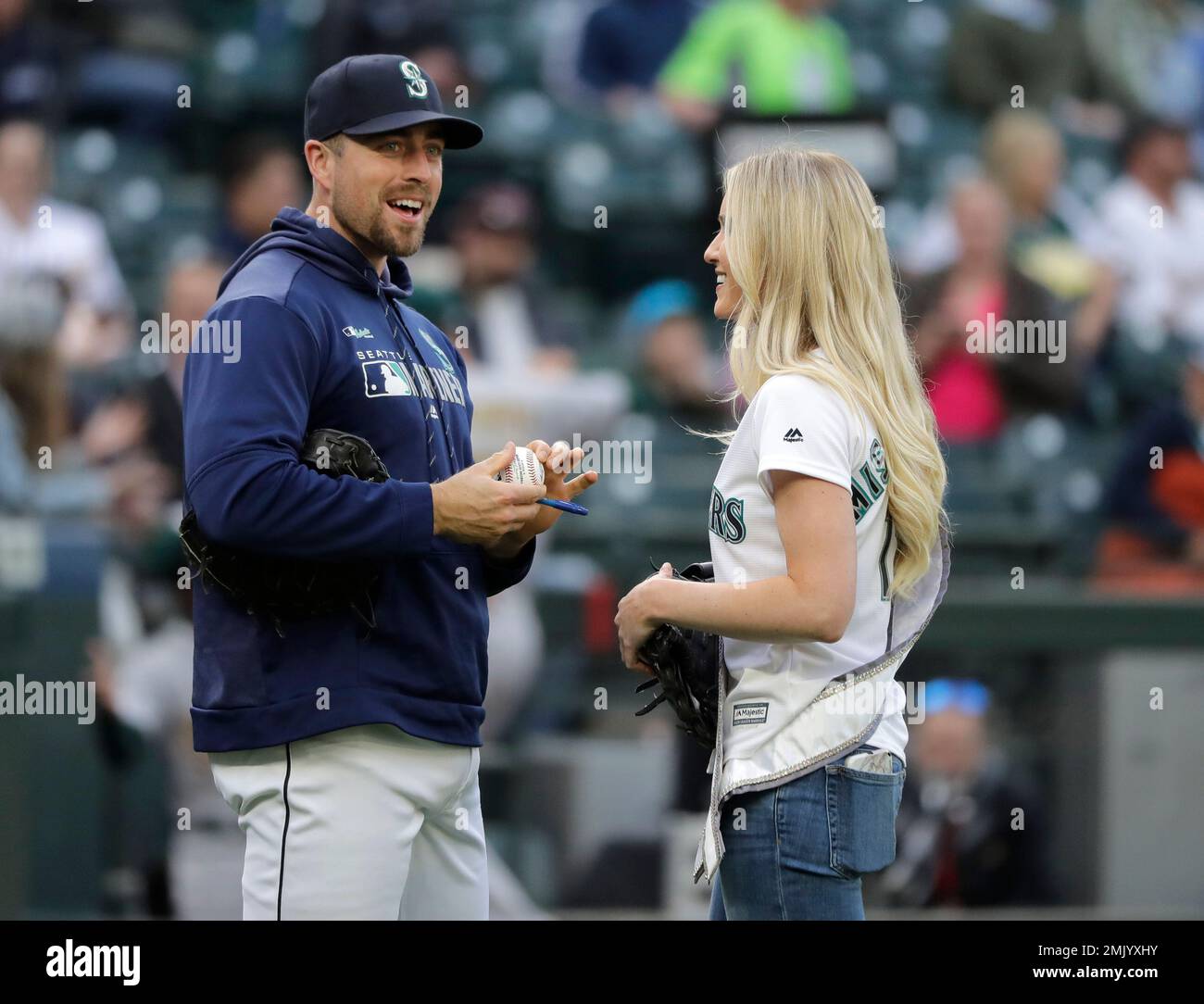 Seattle Mariners catcher Tom Murphy, left, autographs a baseball for ...