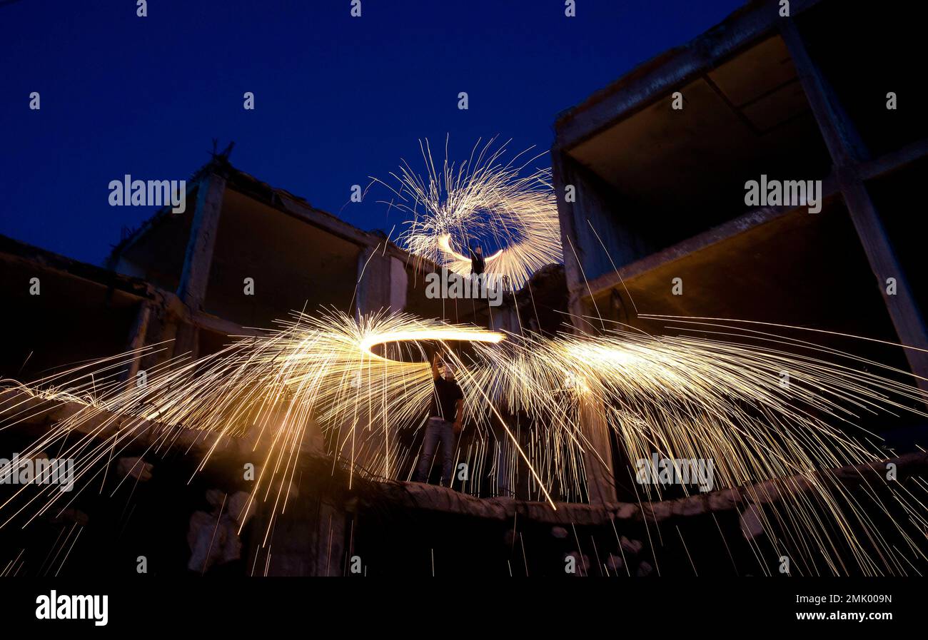 Palestinians light fireworks above the rubble to celebrate the holy ...