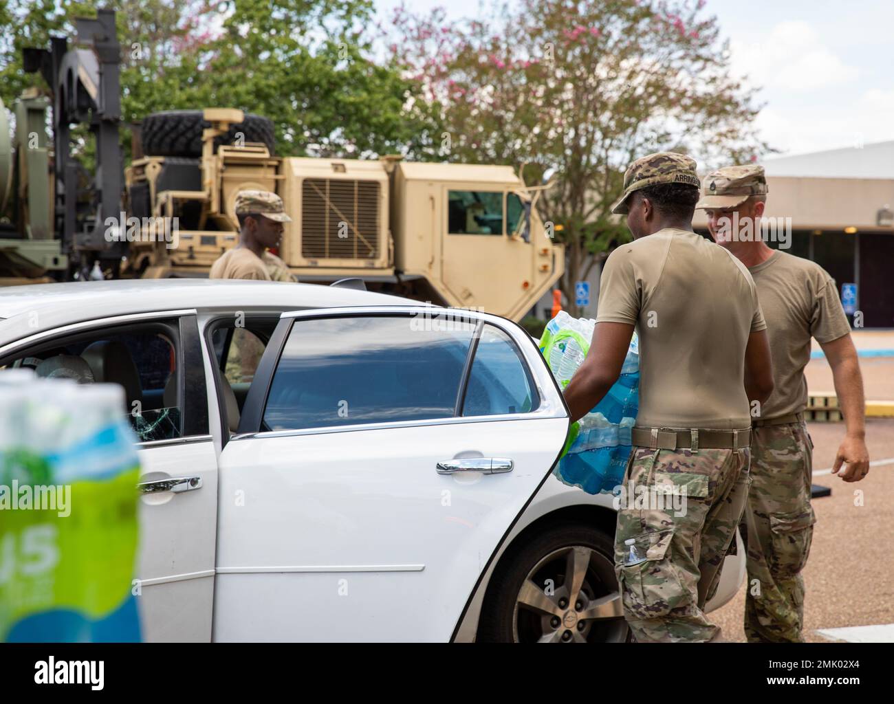 A Mississippi National Guard Soldier puts water in a car at the Hinds ...