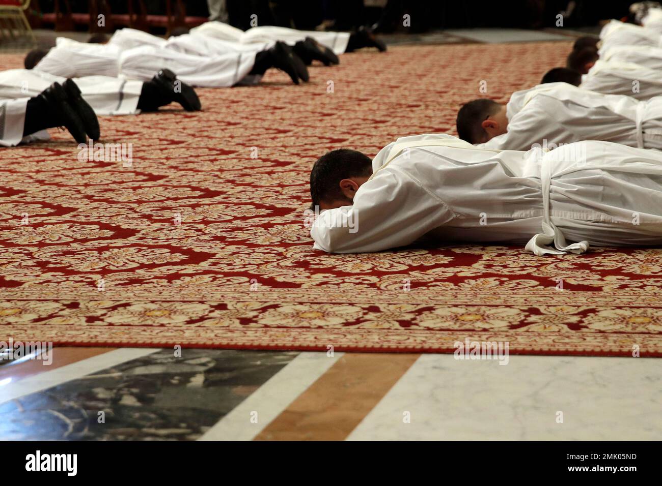 Priests lie face down on the floor during an ordination ceremony ...