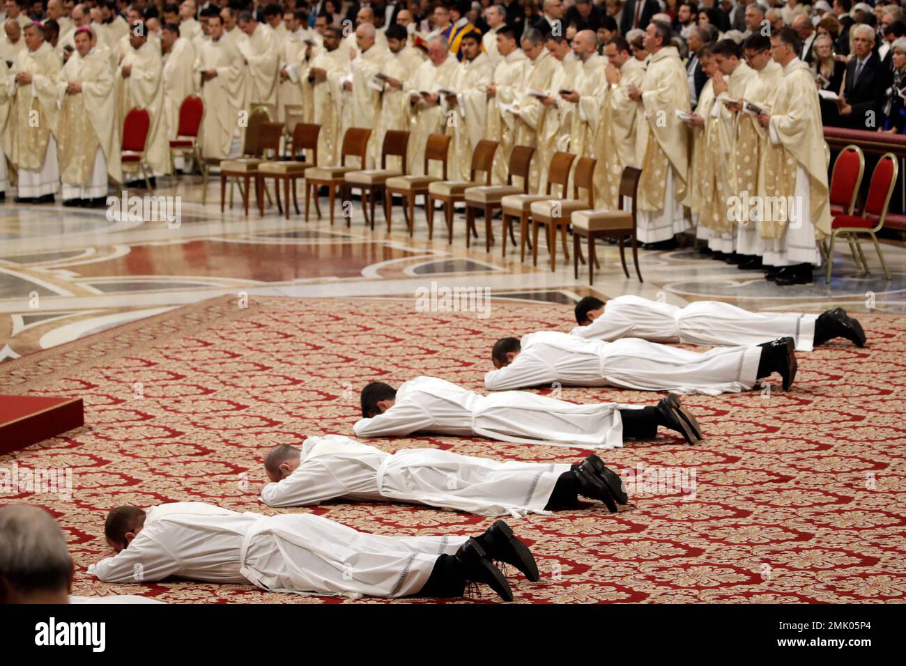 Priests lie face down on the floor during an ordination ceremony ...