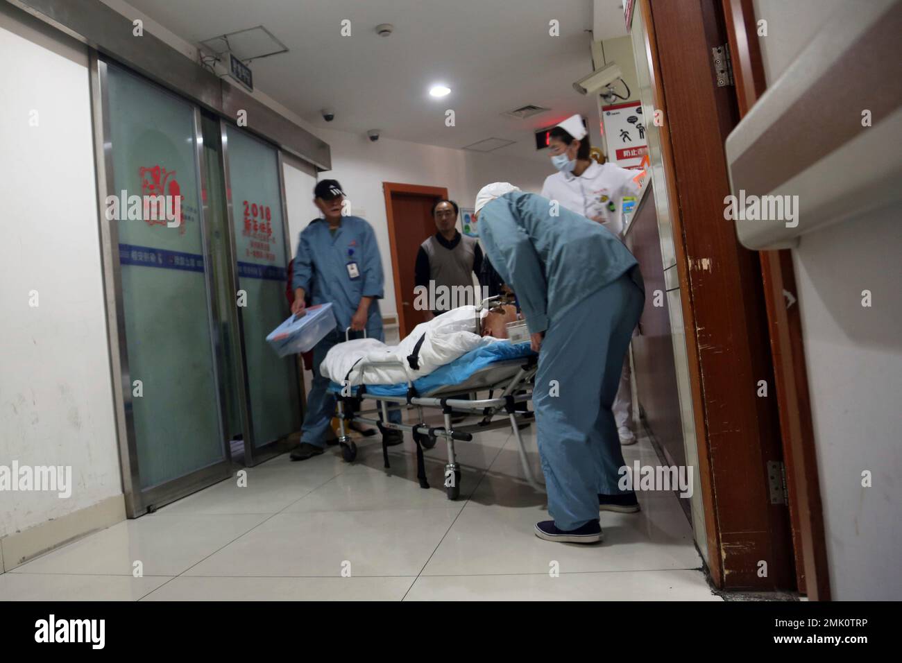 Orderlies roll a brain surgery patient out of the functional ...