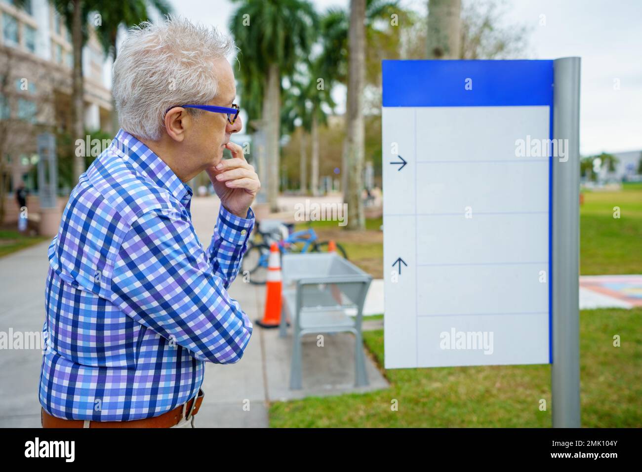 Businessman reading a direction sign Stock Photo - Alamy
