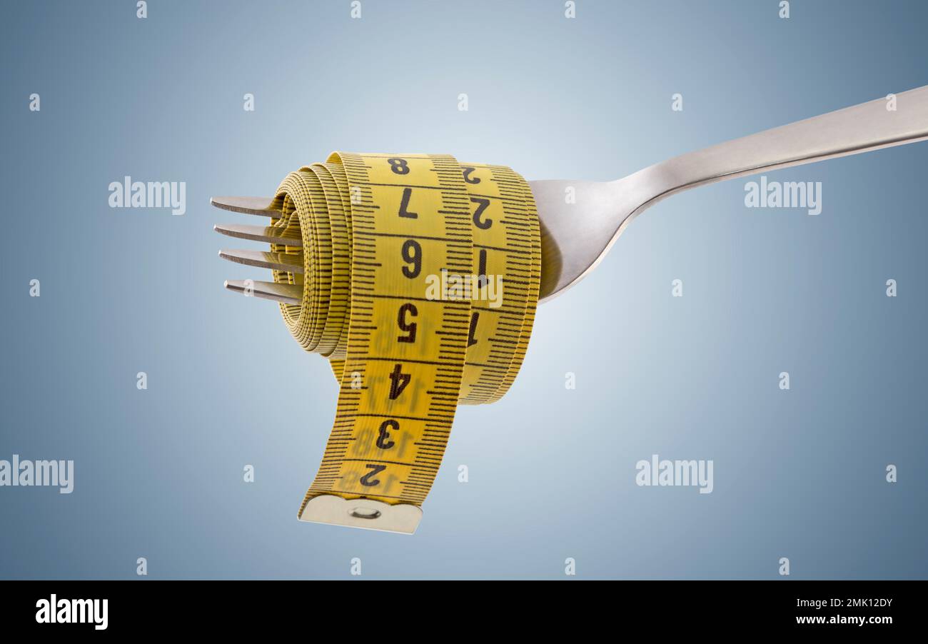 Fork with yellow measuring tape on light blue background. Concept of ...
