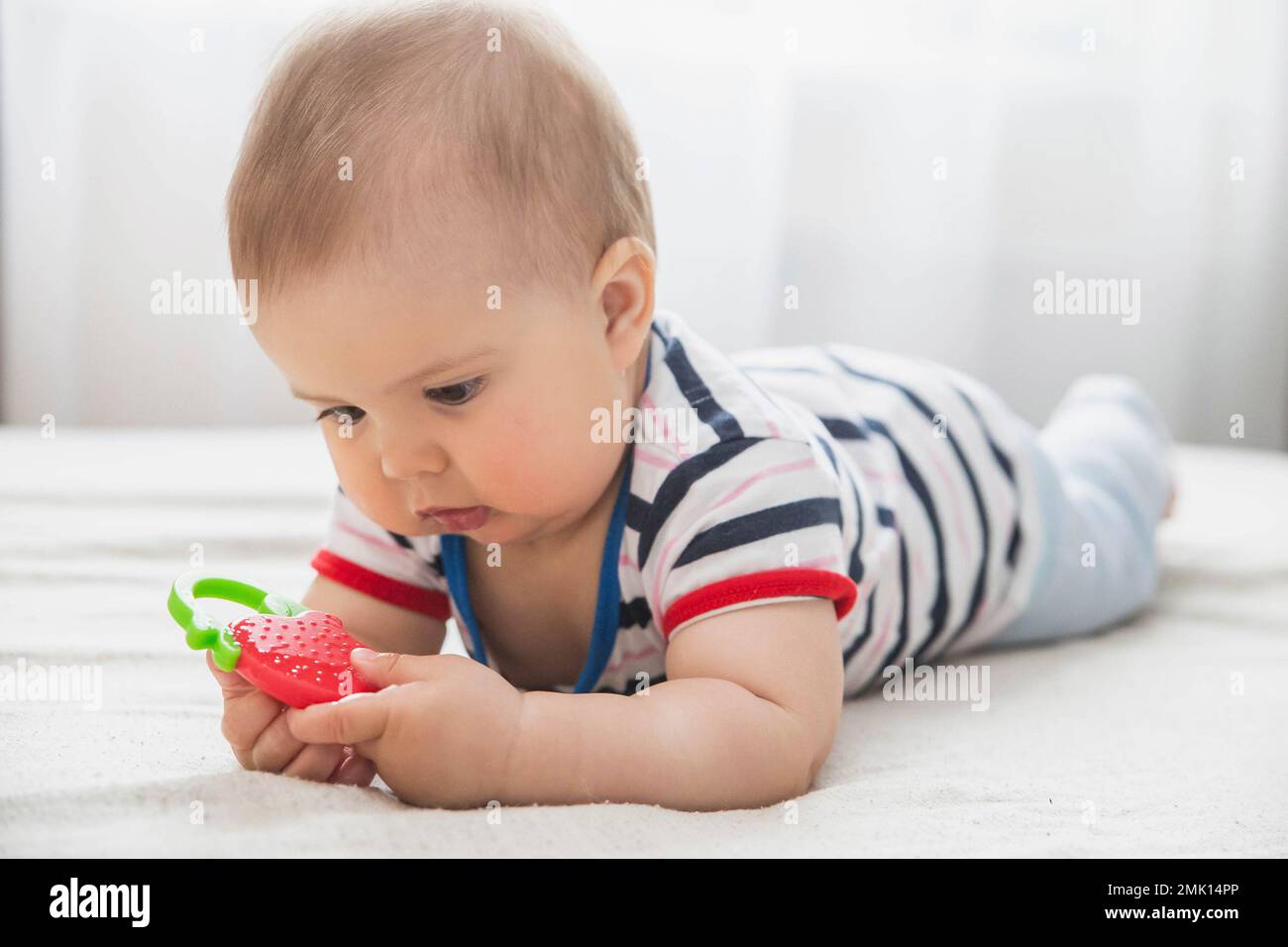 baby is nibble a rubber toy because the teeth are being cut Stock Photo ...