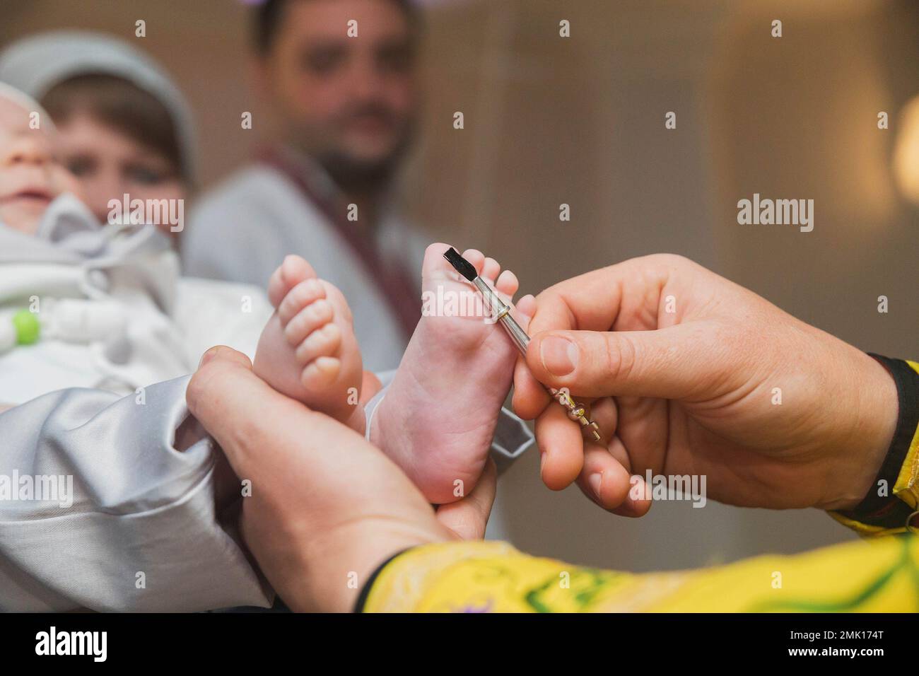 The priest performs the ceremony of anointing the baby Stock Photo - Alamy