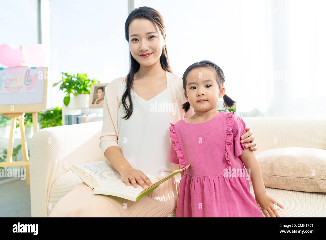 The little girl and her mother read a book together Stock Photo - Alamy