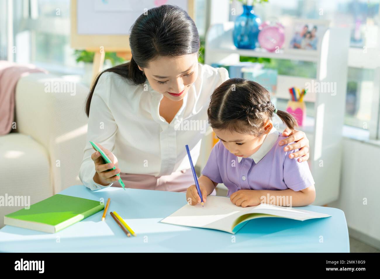 The teacher taught the girl reading a book Stock Photo - Alamy