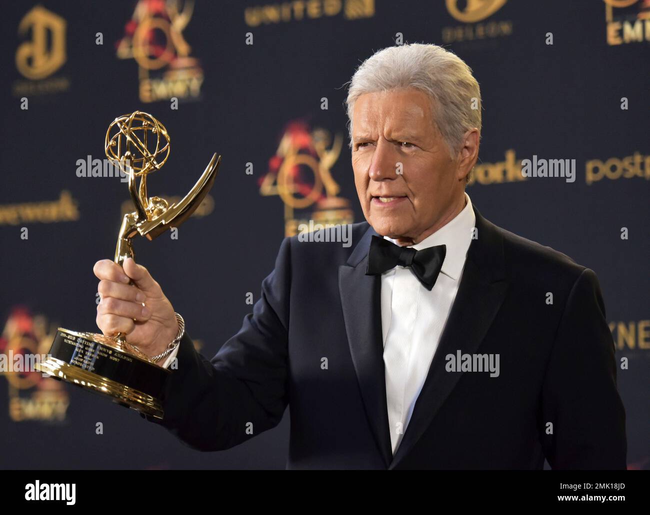 Alex Trebek poses in the press room with the award for outstanding game ...