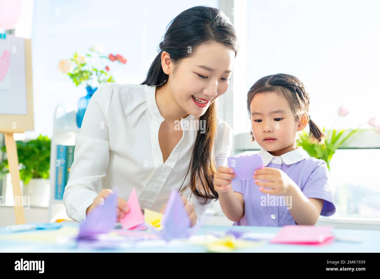 The teacher with little girl origami Stock Photo - Alamy