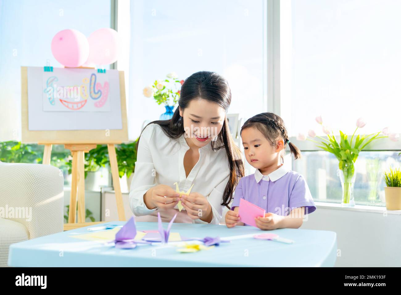 The teacher with little girl origami Stock Photo - Alamy
