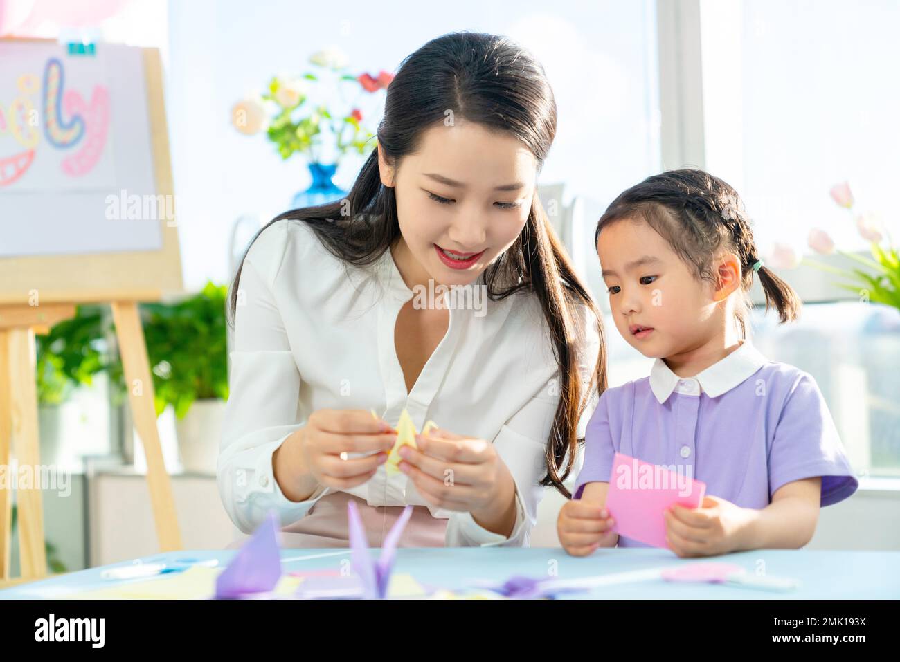 The teacher with little girl origami Stock Photo - Alamy