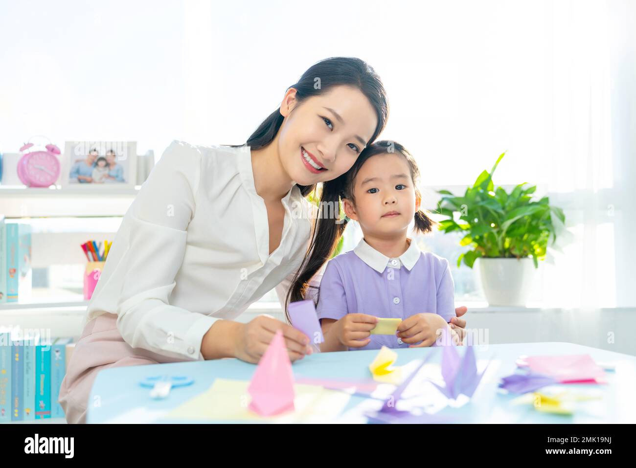 The teacher with little girl origami Stock Photo - Alamy