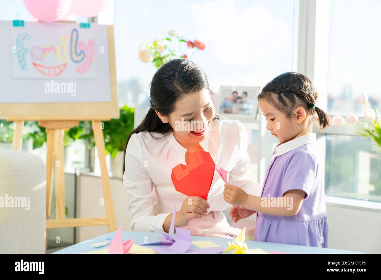 The teacher with little girl origami Stock Photo - Alamy