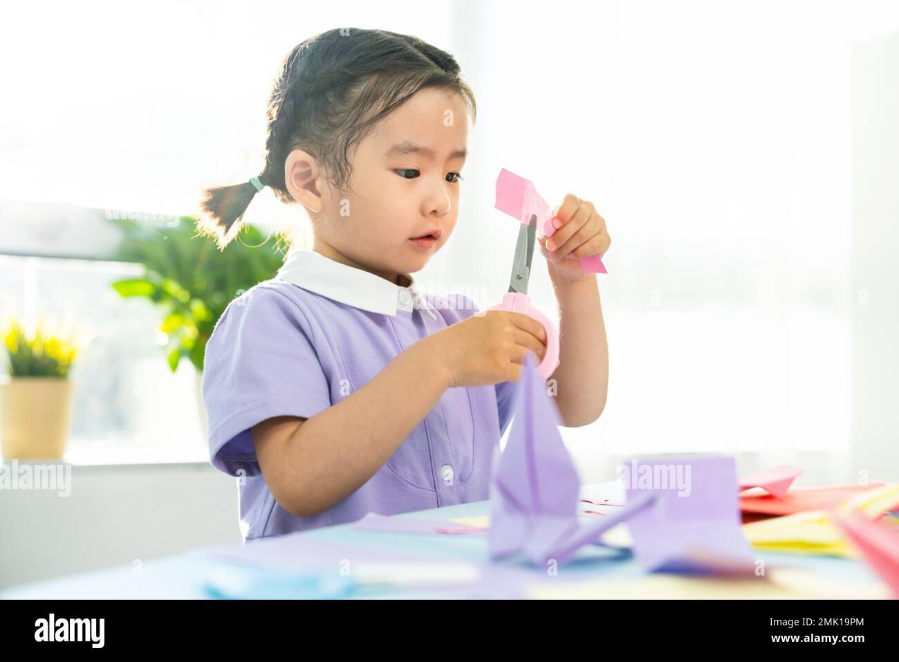Little girl cutting paper scissors hi-res stock photography and images ...