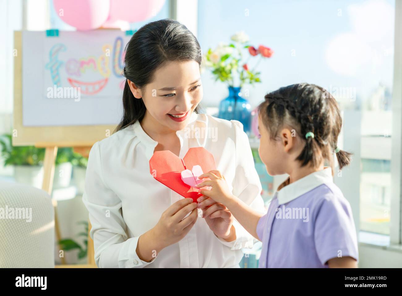 The teacher with little girl origami Stock Photo - Alamy