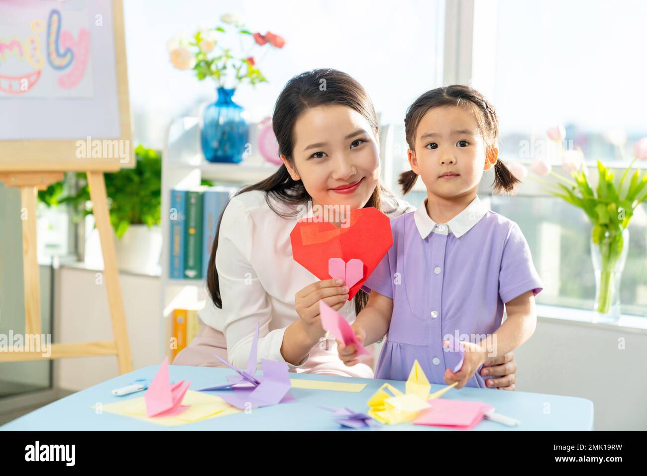 The teacher with little girl origami Stock Photo - Alamy