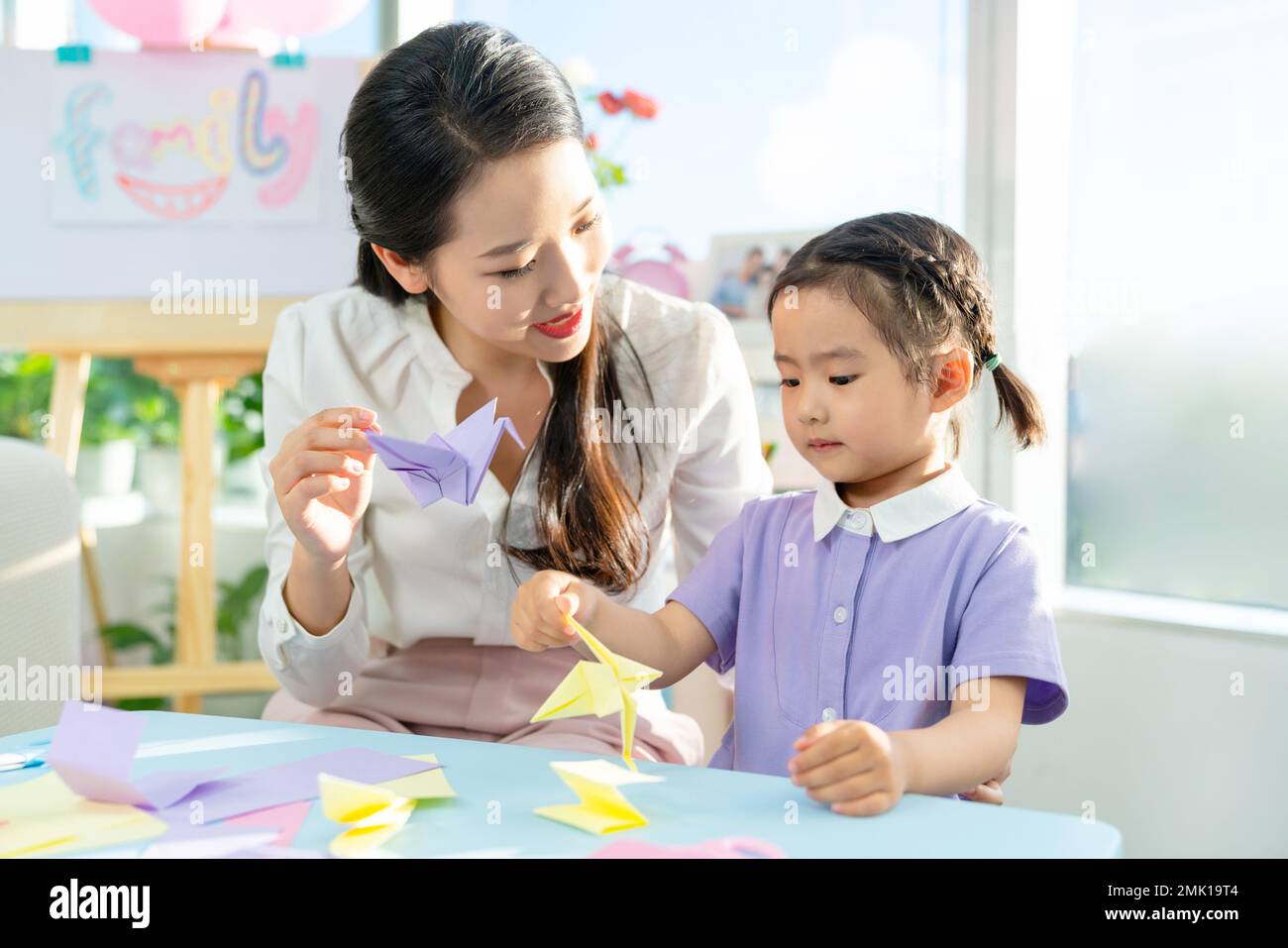 The teacher with little girl origami Stock Photo - Alamy