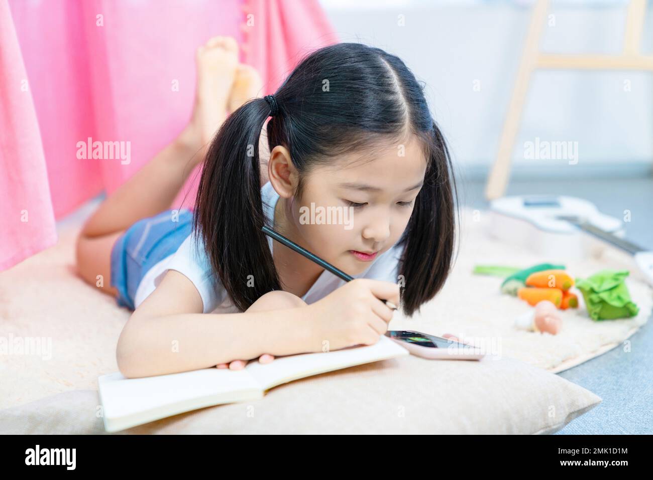 The little girl do homework on the floor Stock Photo - Alamy