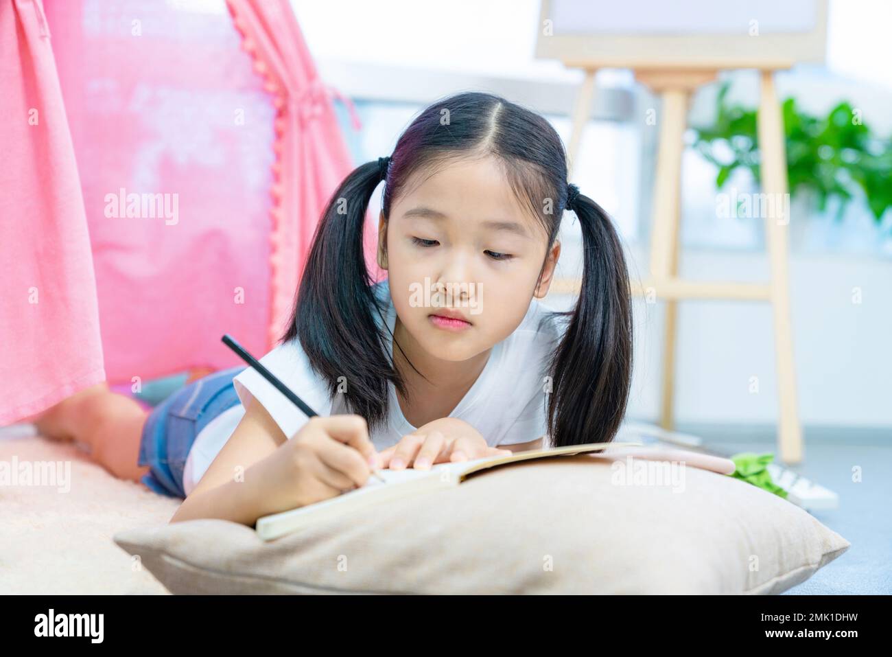 The little girl do homework on the floor Stock Photo - Alamy