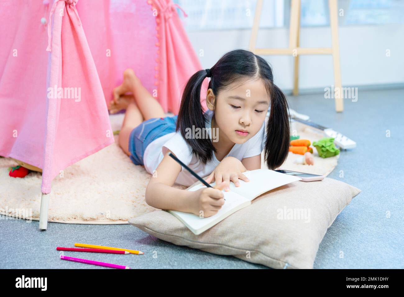 The little girl do homework on the floor Stock Photo - Alamy