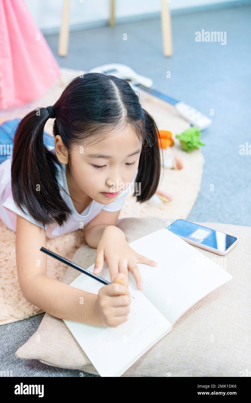 The little girl do homework on the floor Stock Photo - Alamy