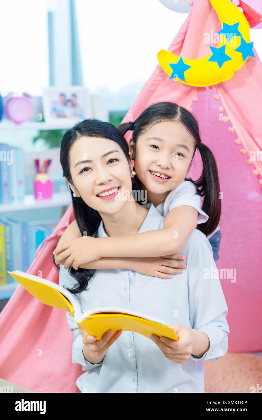The little girl and her mother read a book together Stock Photo - Alamy