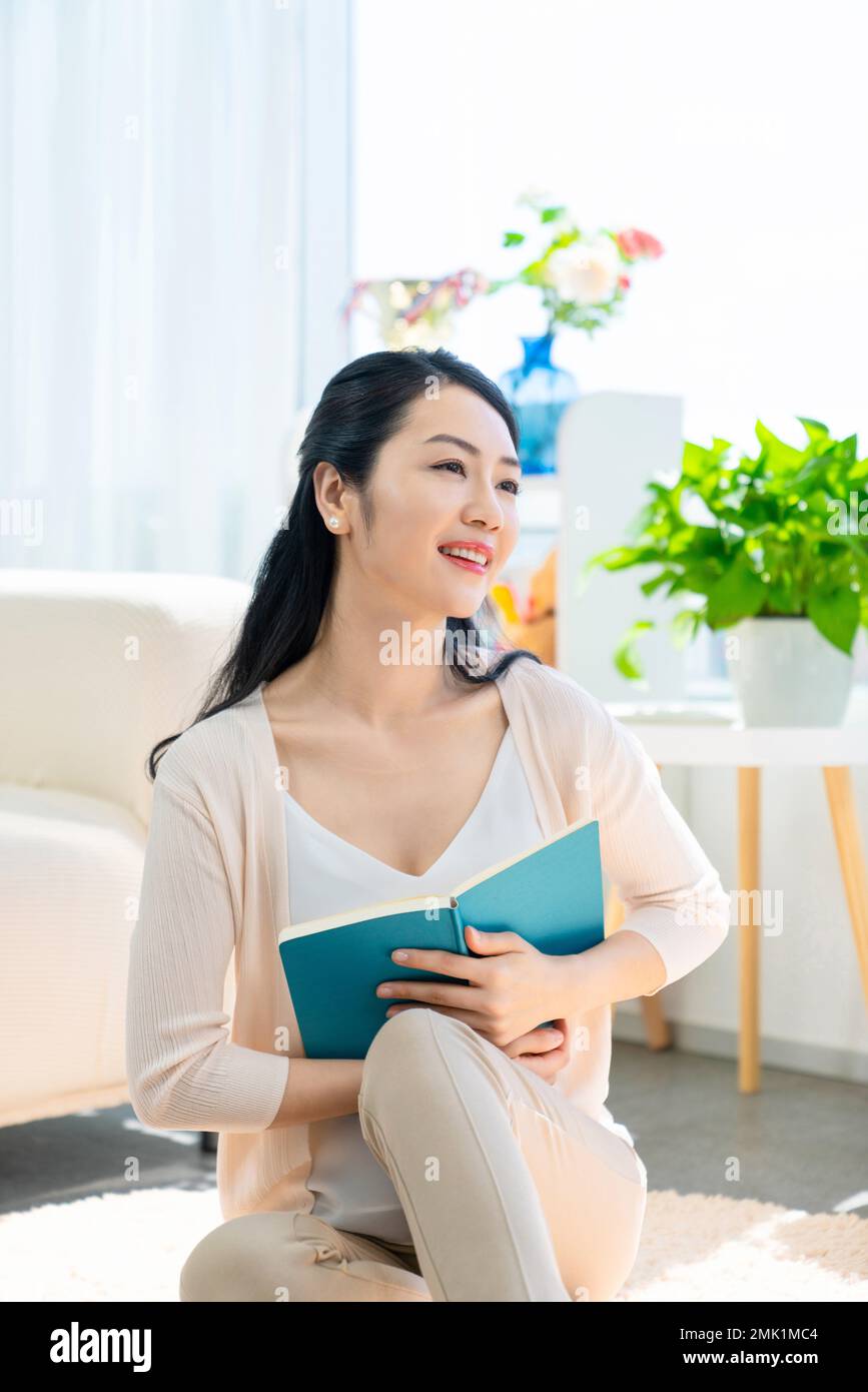 The young lady at home reading a book Stock Photo - Alamy