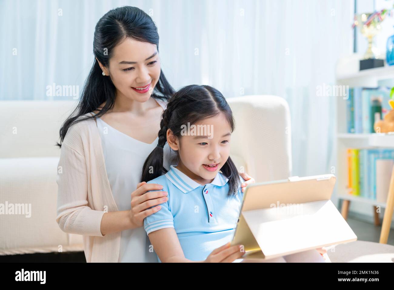 The little girl with her mother to use tablet Stock Photo - Alamy
