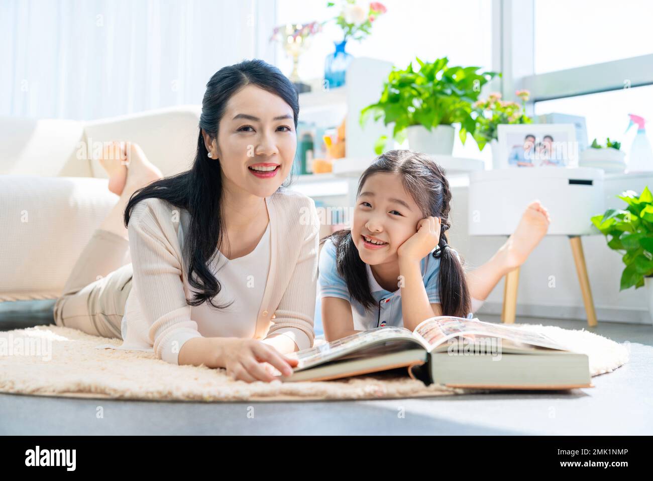 The little girl and her mother read a book together Stock Photo - Alamy