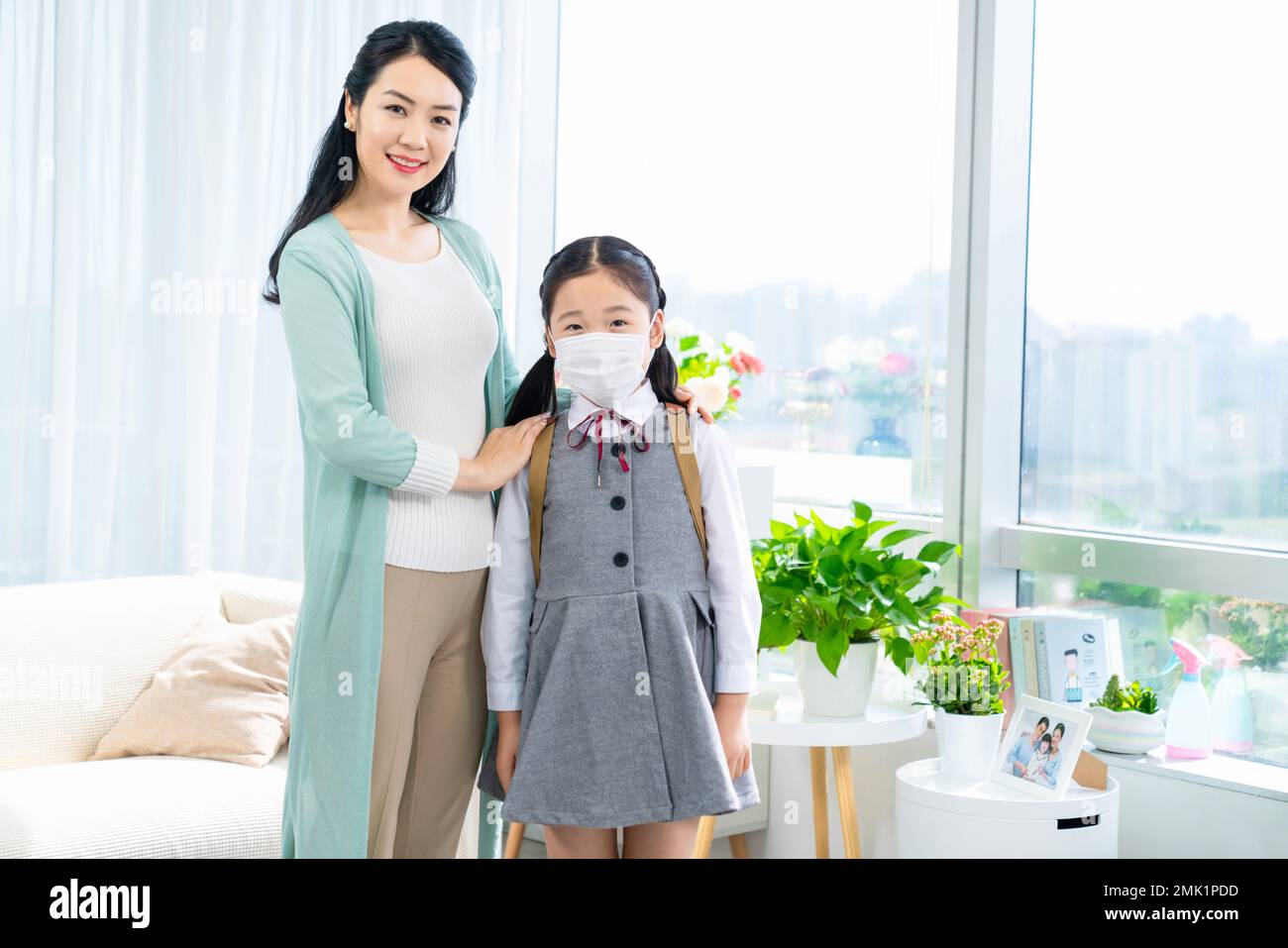 Mother to daughter wearing a mask Stock Photo - Alamy
