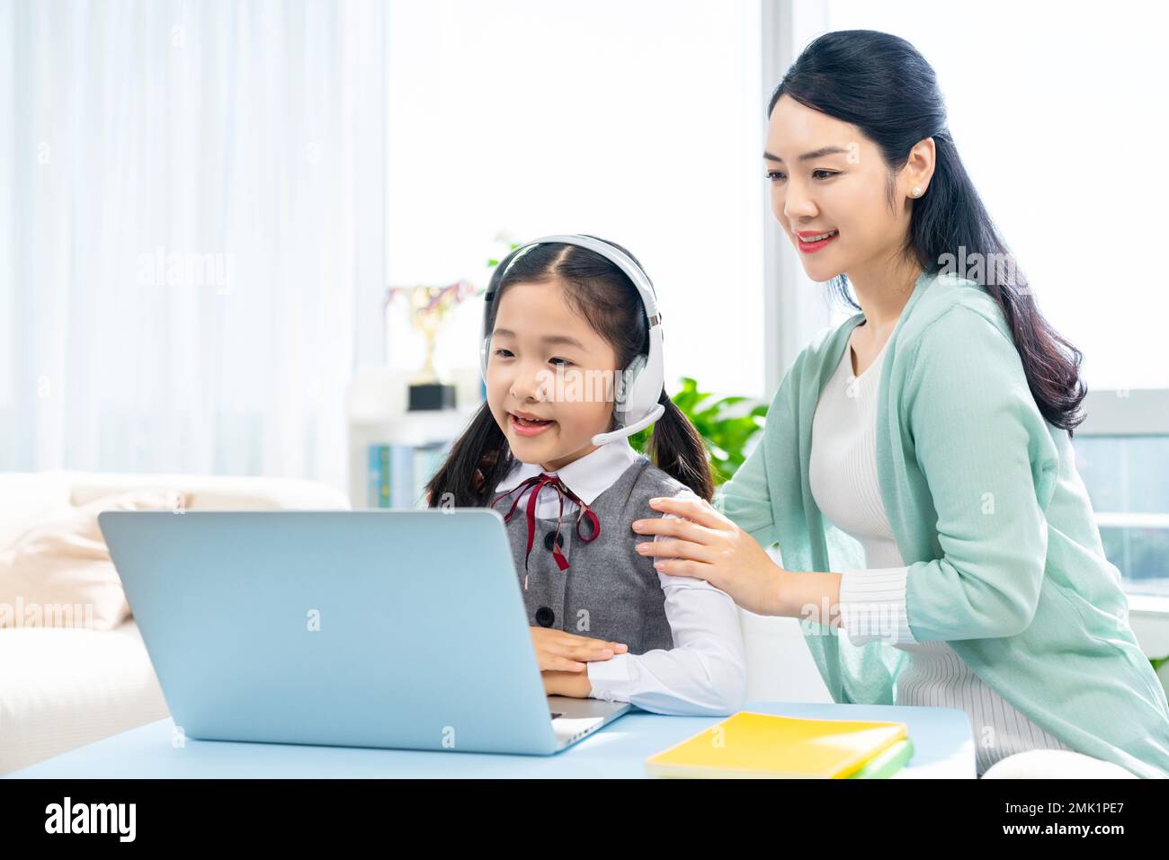 The little girl and her mother together using laptops Stock Photo - Alamy