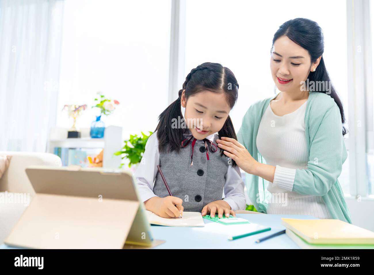 The little girl with her mother to use tablet Stock Photo - Alamy