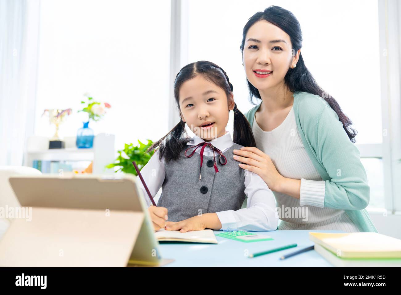 The little girl with her mother to use tablet Stock Photo - Alamy