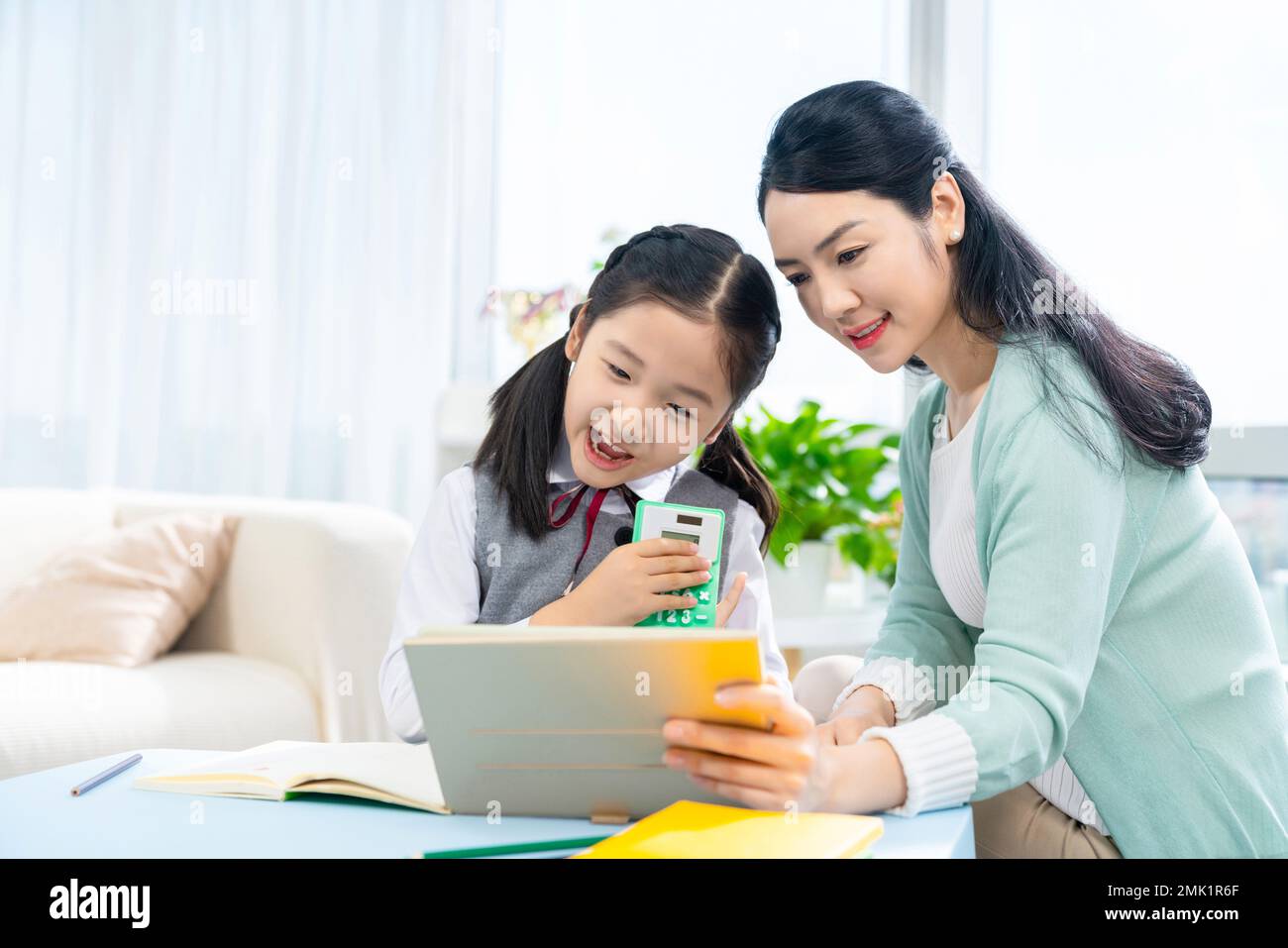 The little girl with her mother to use tablet Stock Photo - Alamy