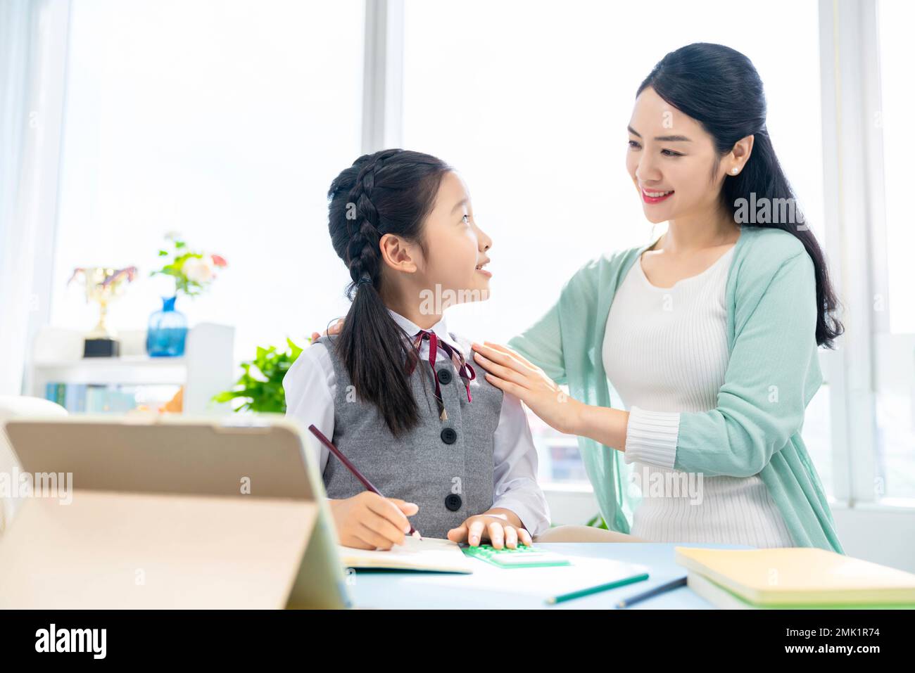 The little girl with her mother to use tablet Stock Photo - Alamy