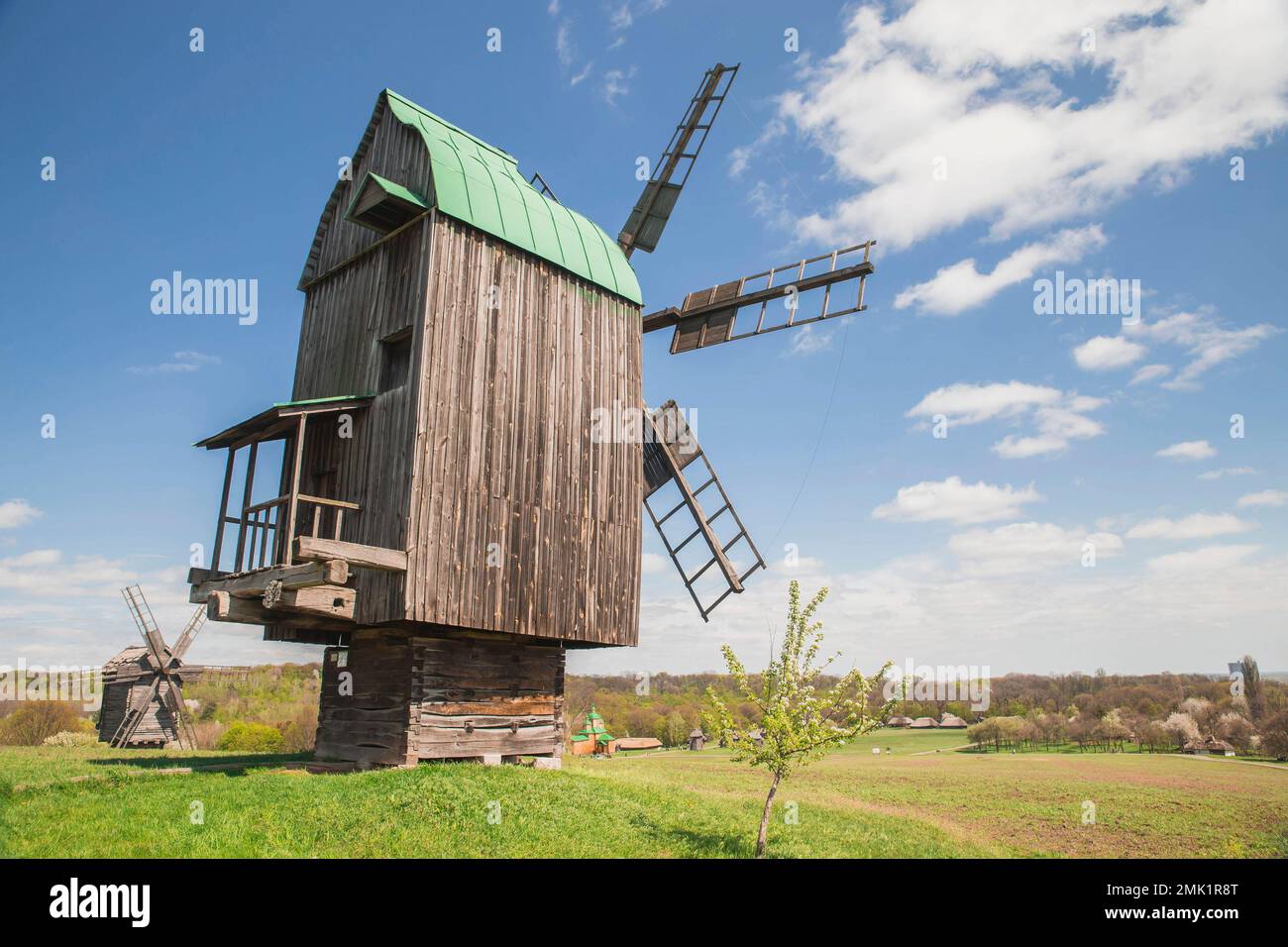 Antique wooden windmills on a hill near the village. Rural landscape ...