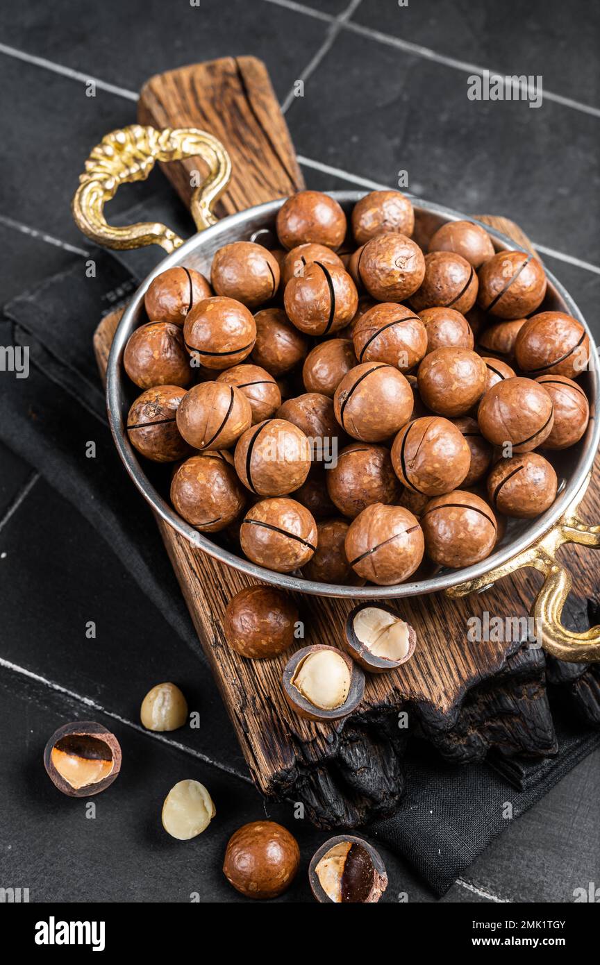 Macadamia nuts in a shell ready to eat. Black background. Top view ...